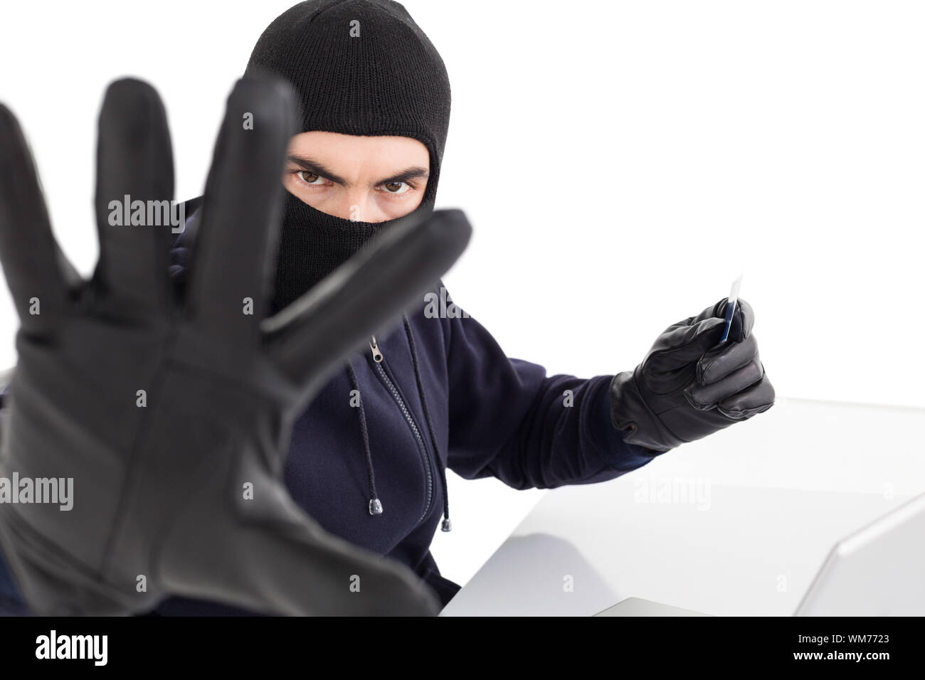 Angry hacker using credit card and gesturing on white background Stock ...