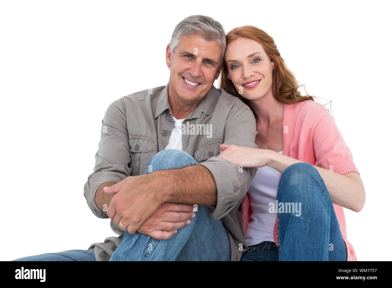 Casual couple sitting and smiling on white background Stock Photo - Alamy