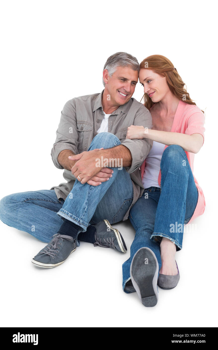Casual couple sitting and smiling on white background Stock Photo - Alamy