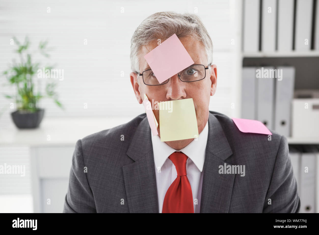 Confused businessman with sticky notes on head in his office Stock ...