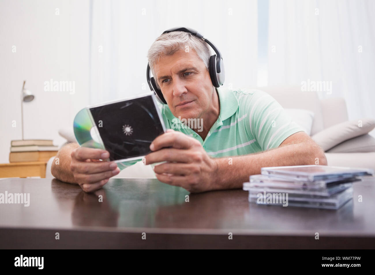 Mature man listening to cds at home in the living room Stock Photo - Alamy