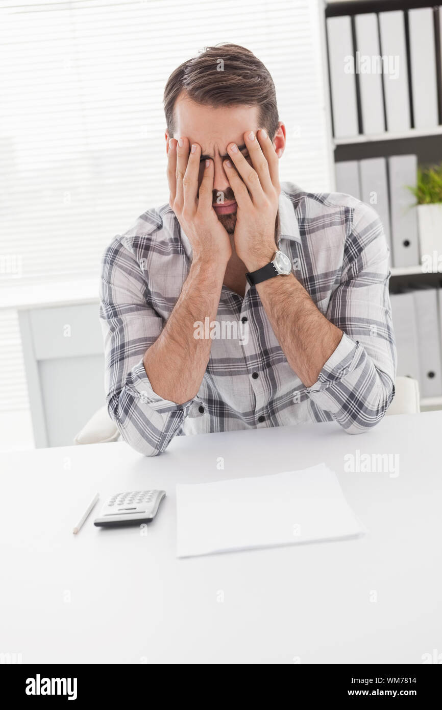 Casual businessman feeling stressed at his desk in his office Stock ...