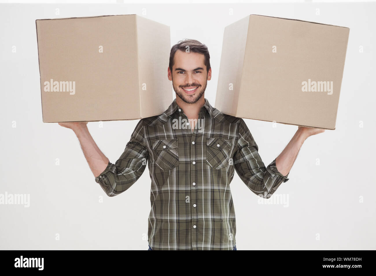 Happy man holding moving boxes at home in the living room Stock Photo ...