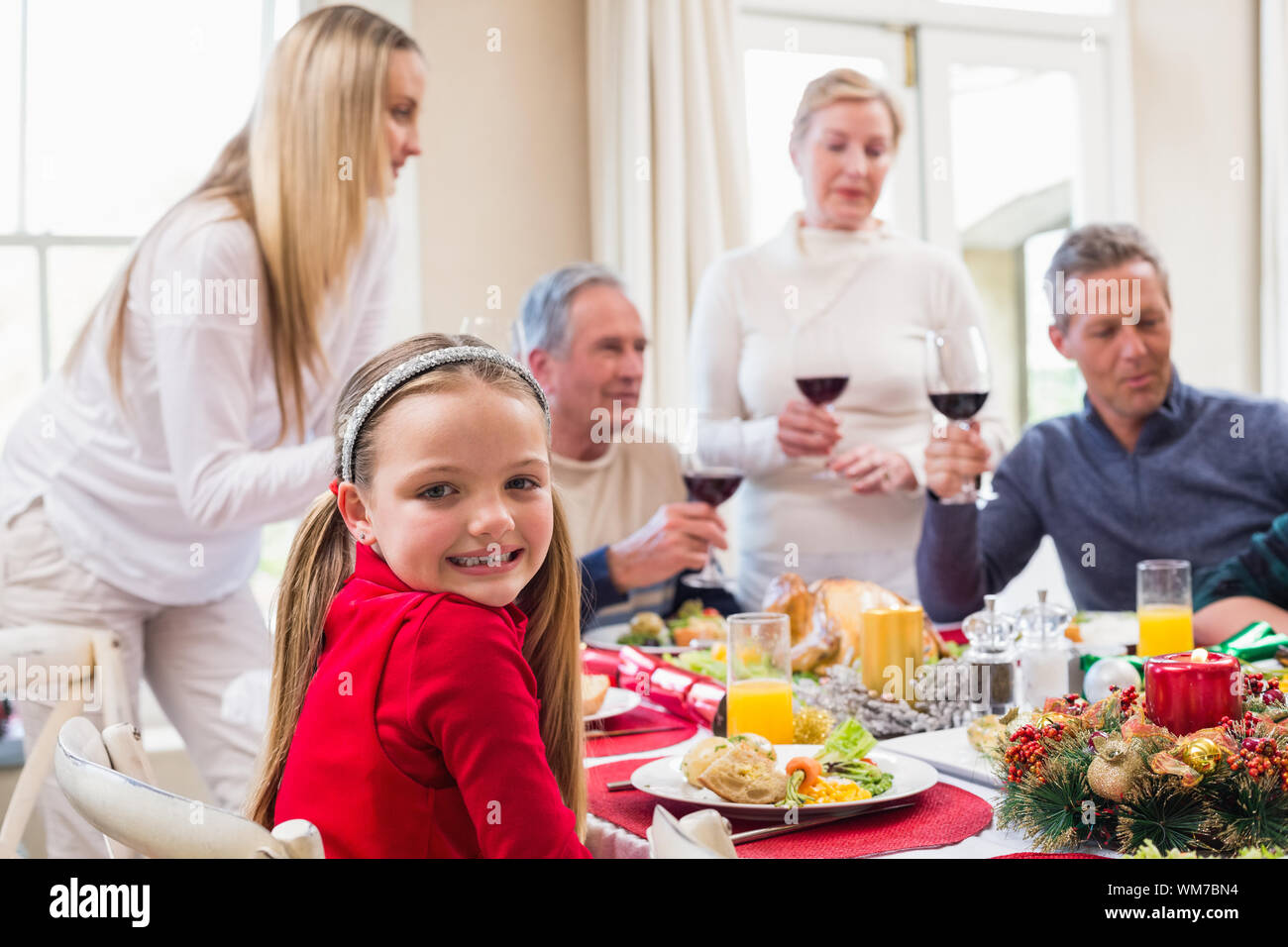 Portrait of a pretty little girl in a christmas dinner at home in the ...