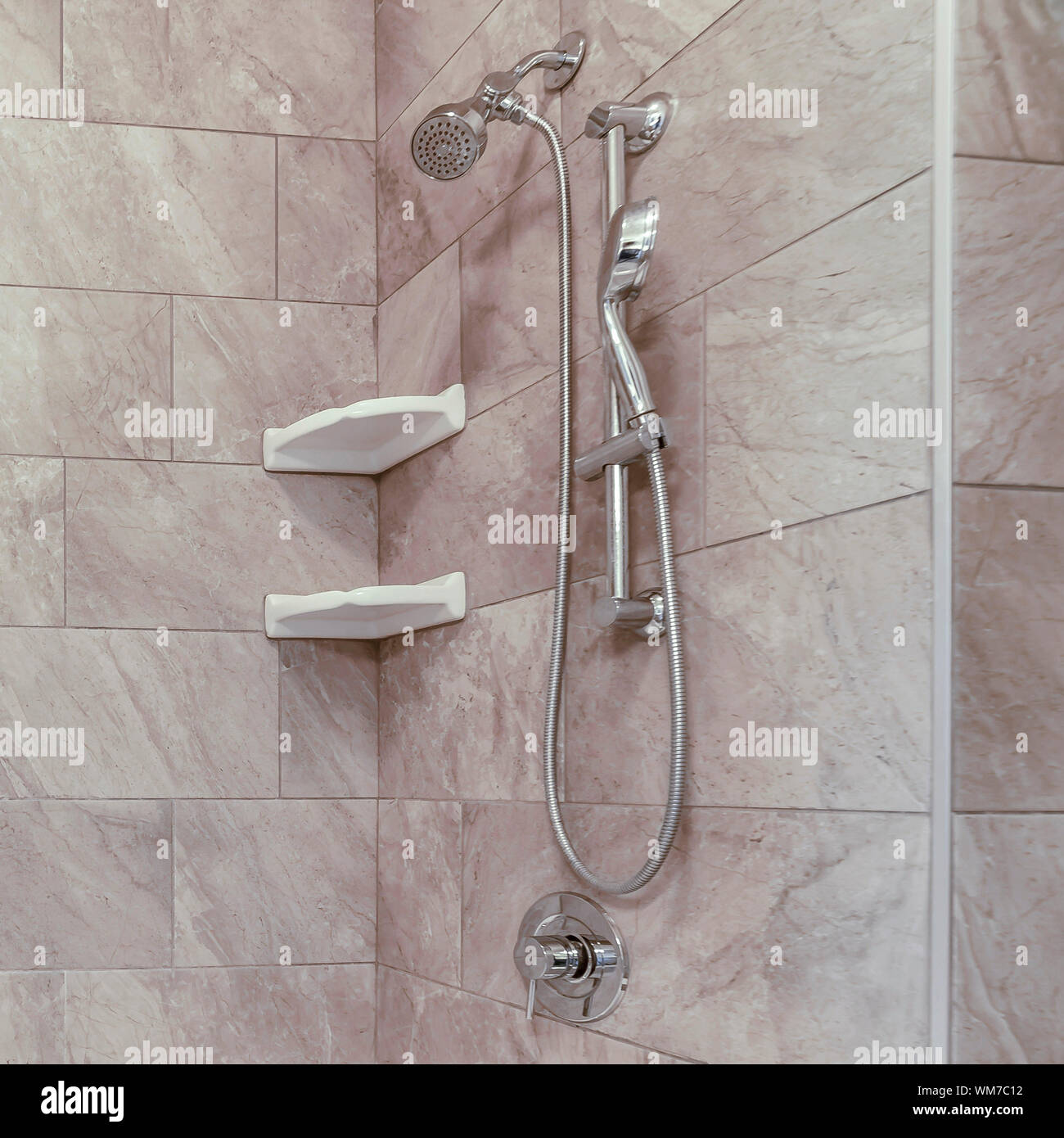 Square Square bathtub and stainless steel shower against gray and white ...