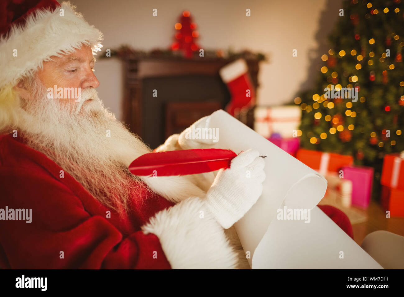 Santa claus writing his list on scroll at home in the living room Stock ...
