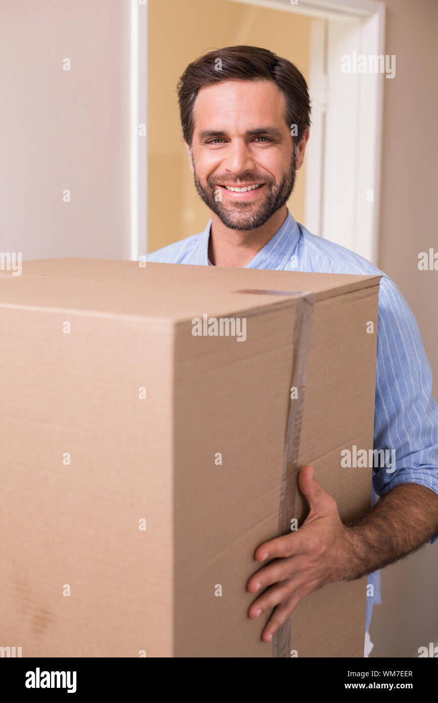 Happy man carrying moving box in his new home Stock Photo - Alamy