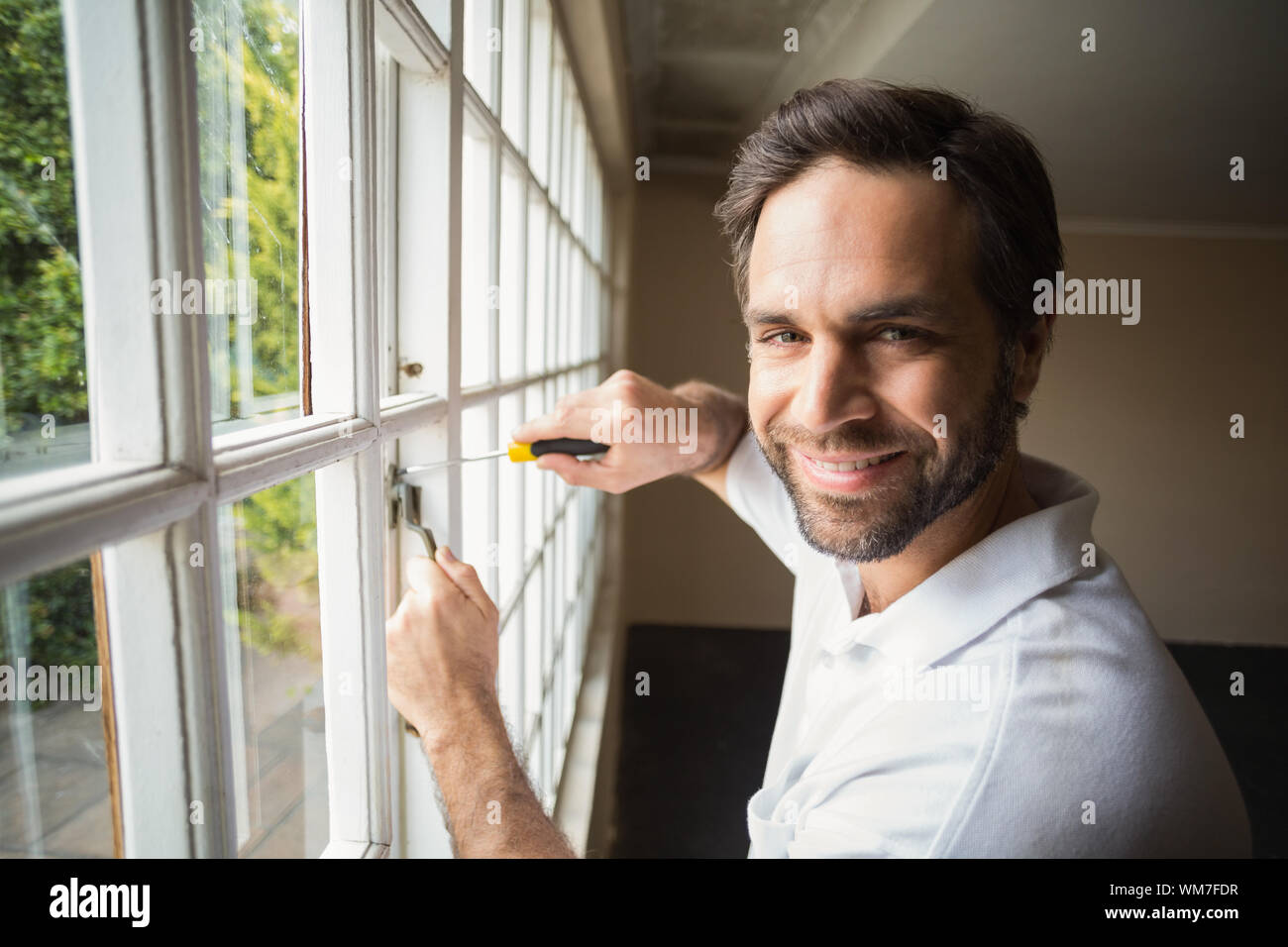 Construction worker fixing the window in a new house Stock Photo - Alamy