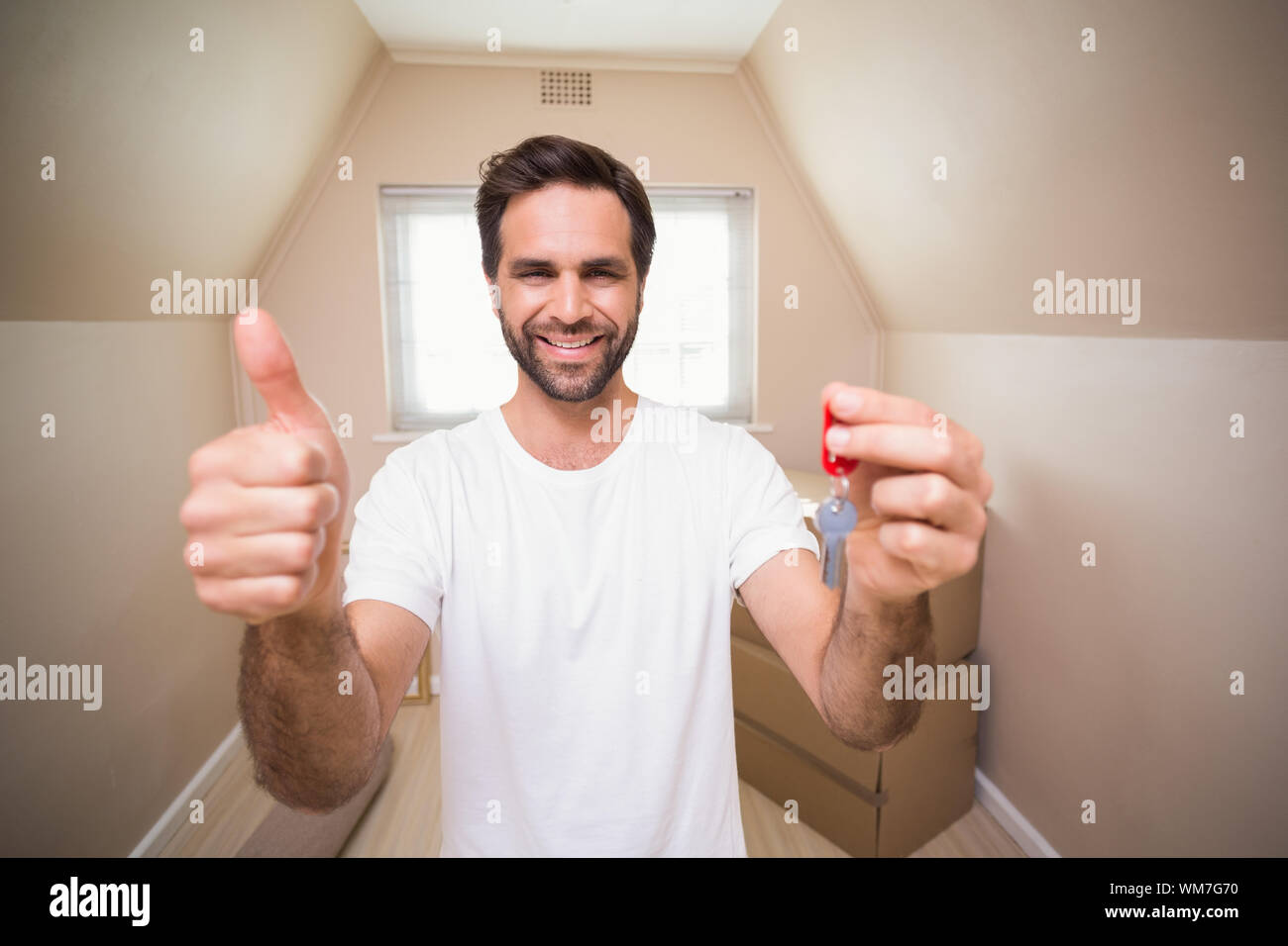 Casual man showing his house key in his new home Stock Photo - Alamy