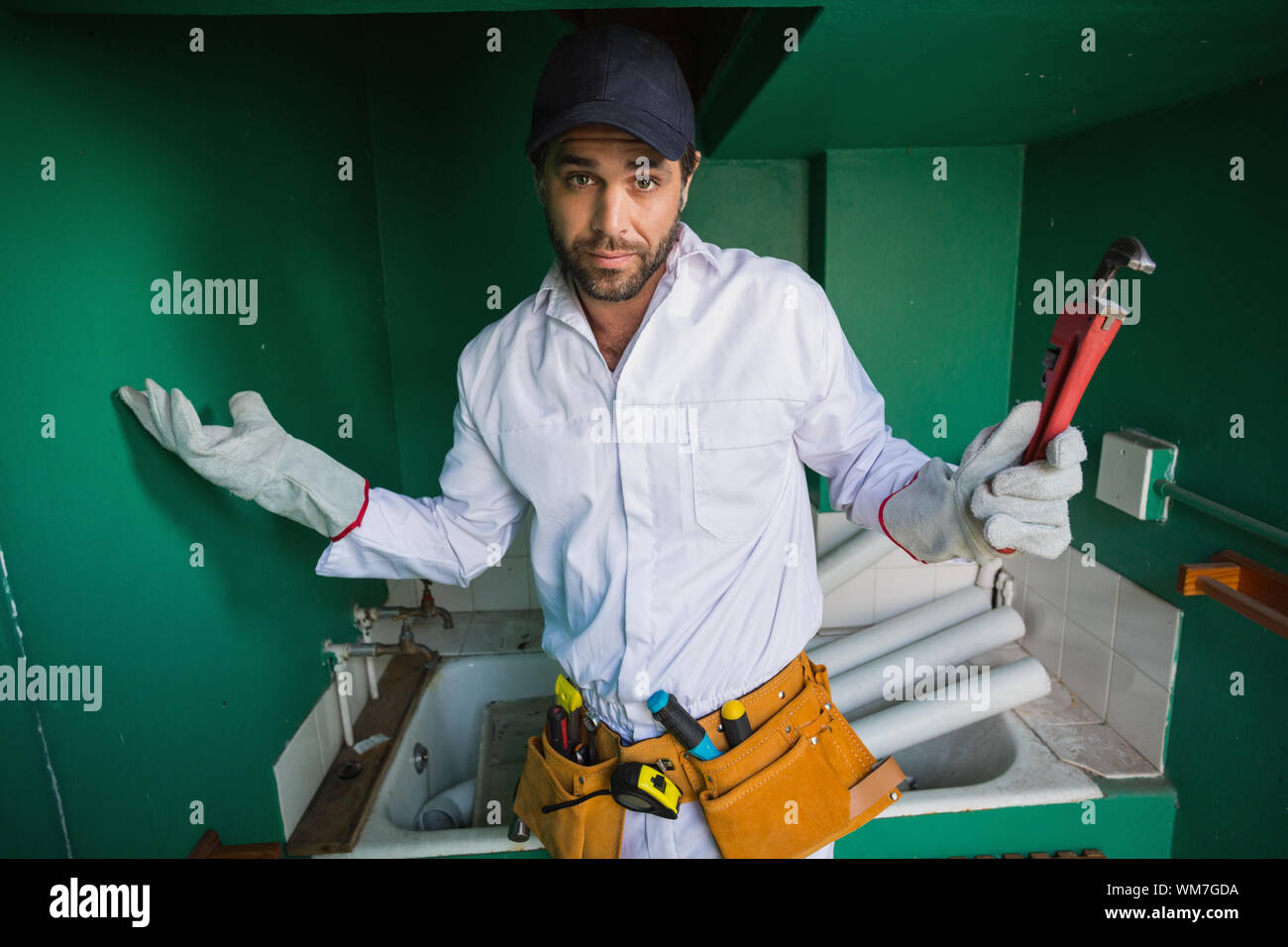 Construction worker shrugging at camera in a new house Stock Photo - Alamy