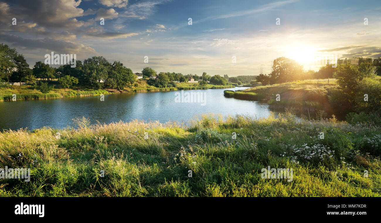 Blue river under clouds at the sunset Stock Photo - Alamy