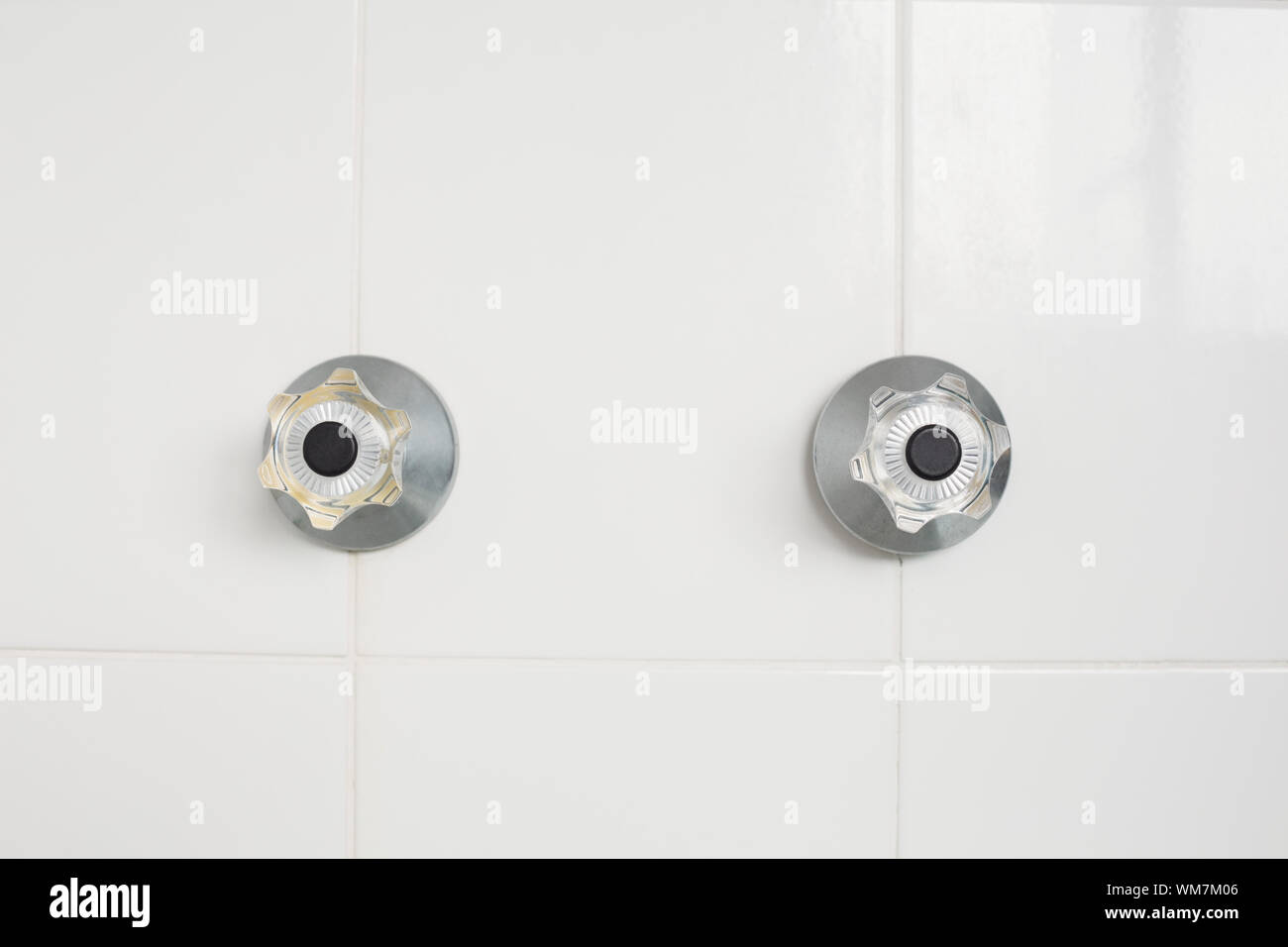 Taps on tiled wall in the bathroom Stock Photo - Alamy