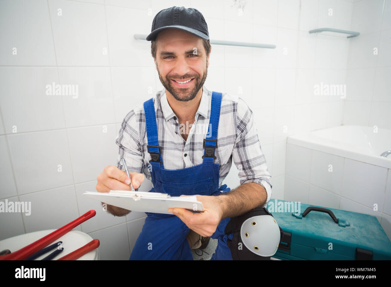 Plumber taking notes on clipboard in the bathroom Stock Photo - Alamy
