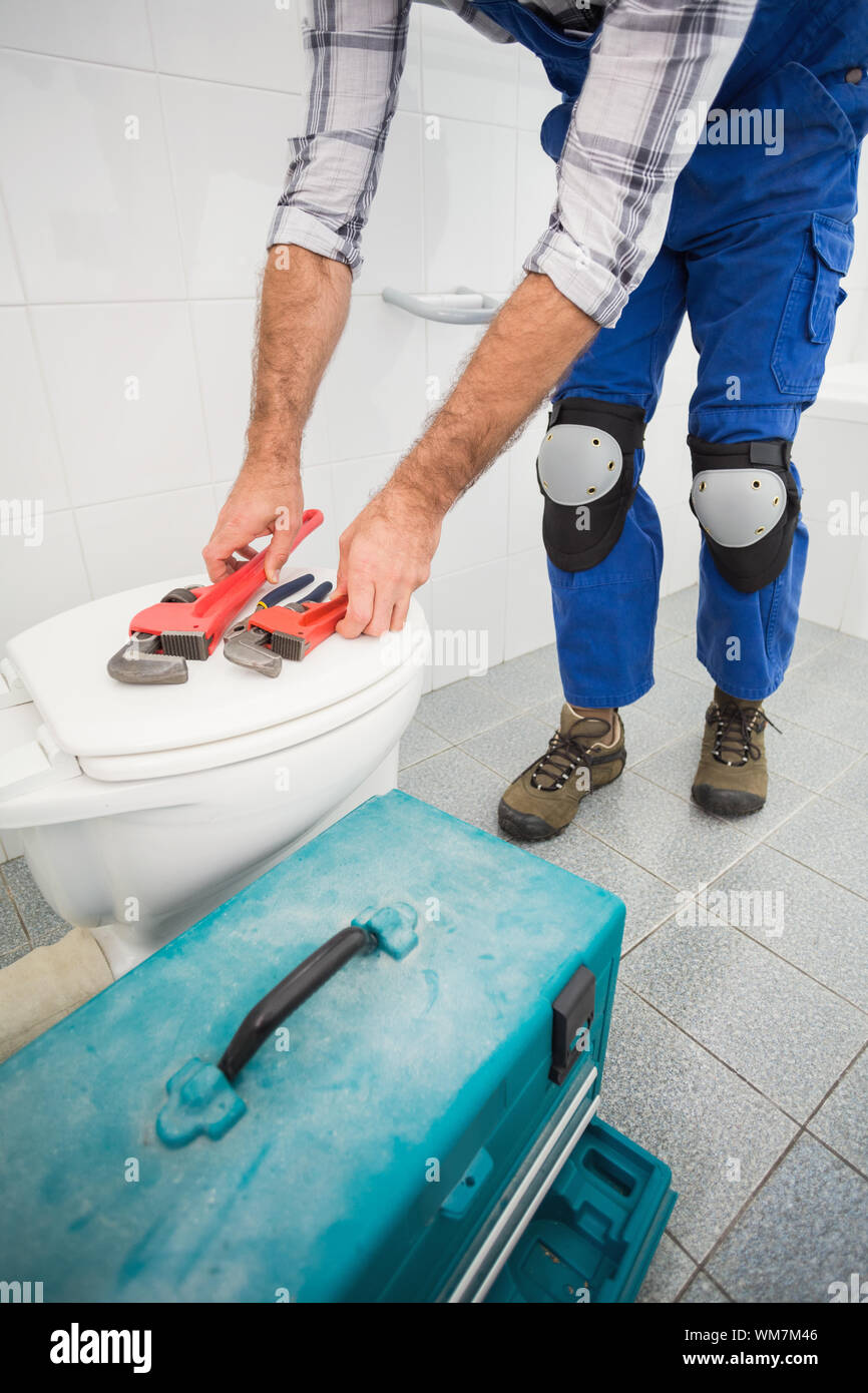 Plumber putting his tools on toilet in the bathroom Stock Photo - Alamy
