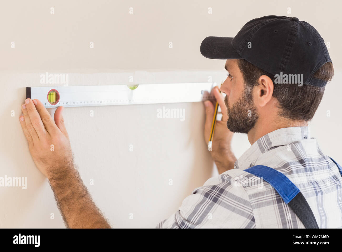 Construction worker using spirit level in a new house Stock Photo - Alamy