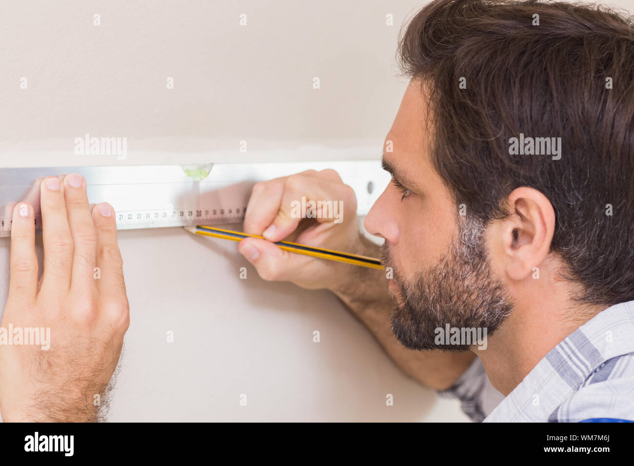 Construction worker using spirit level in a new house Stock Photo - Alamy