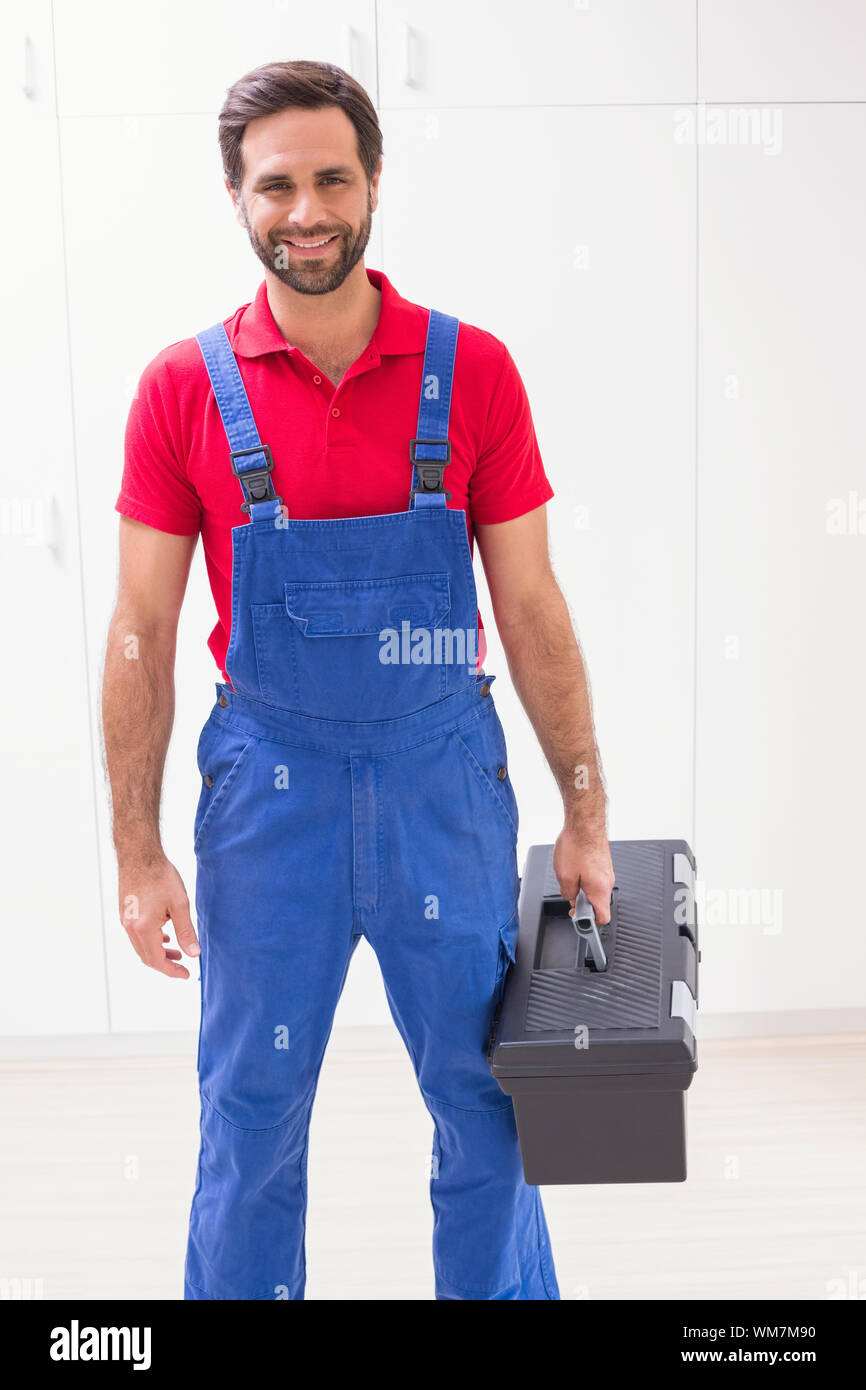 Construction worker holding tool box in a new house Stock Photo - Alamy