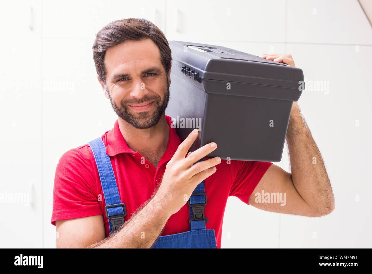 Construction worker holding tool box in a new house Stock Photo - Alamy