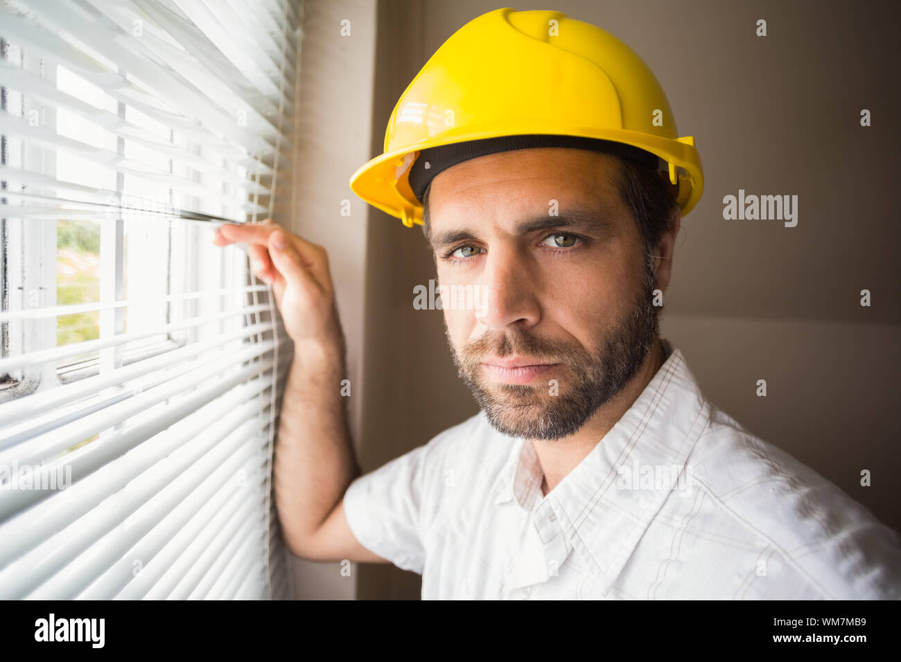 Handyman looking out the window in a new house Stock Photo - Alamy