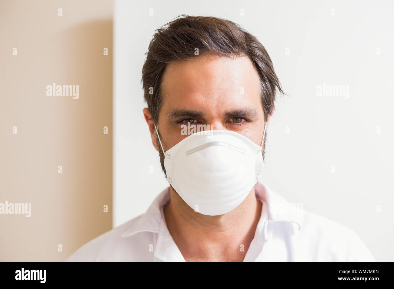 Carpenter wearing protective mask looking at camera in a new house ...