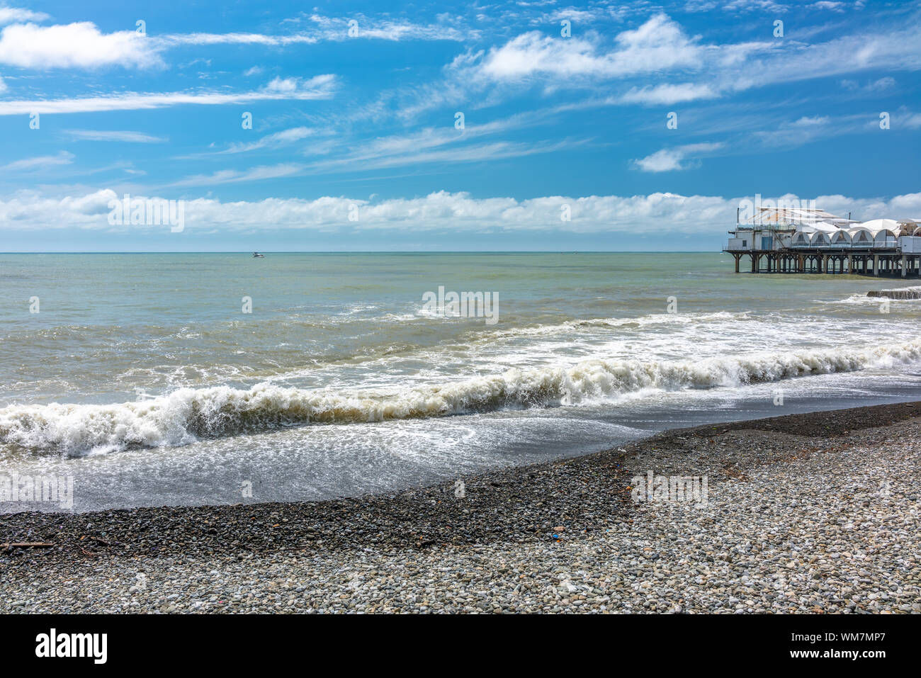 Platform on supports in the sea near the shore. Low dense clouds over ...