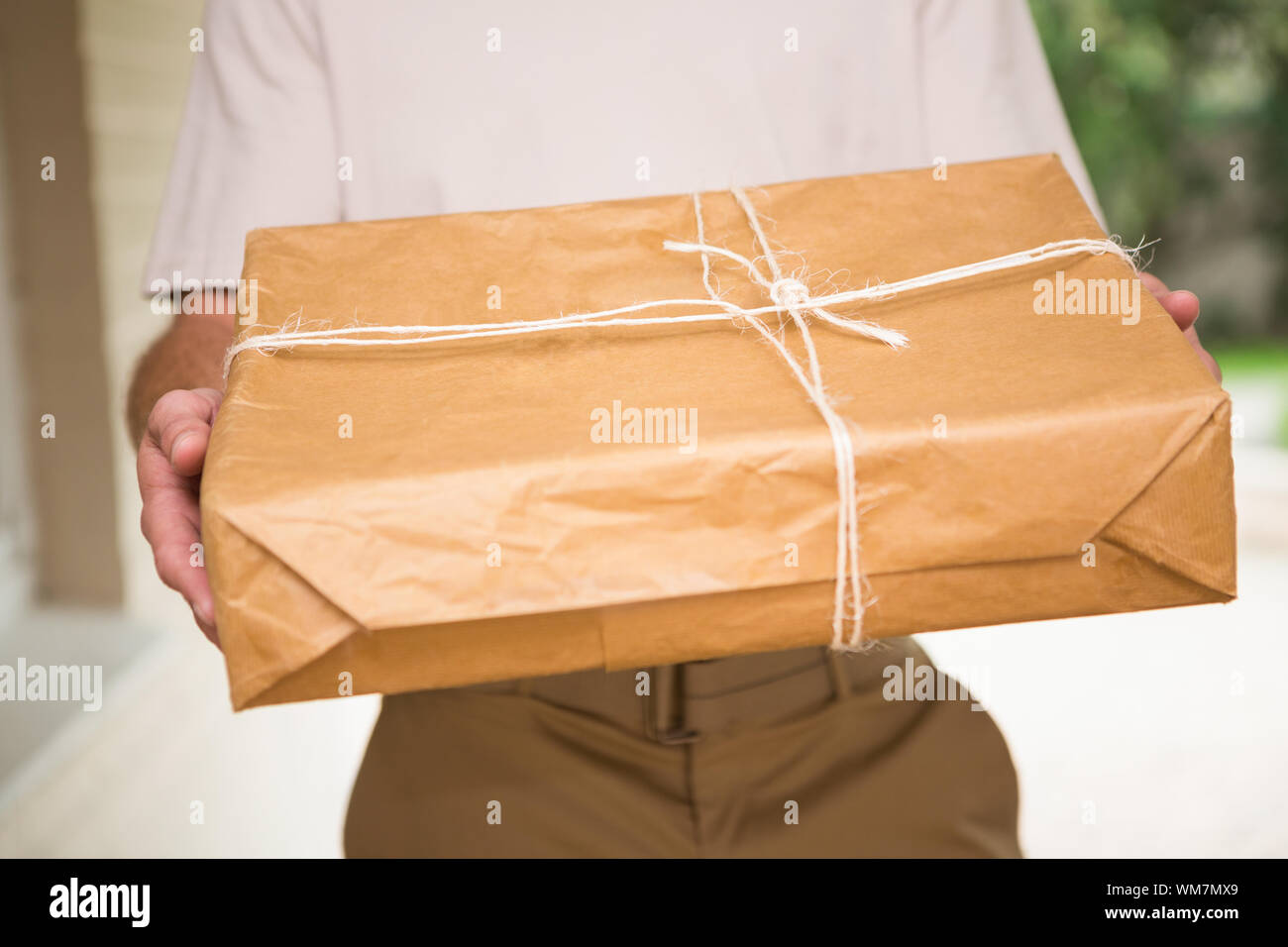 Close up of delivery man giving package outside the warehouse Stock ...