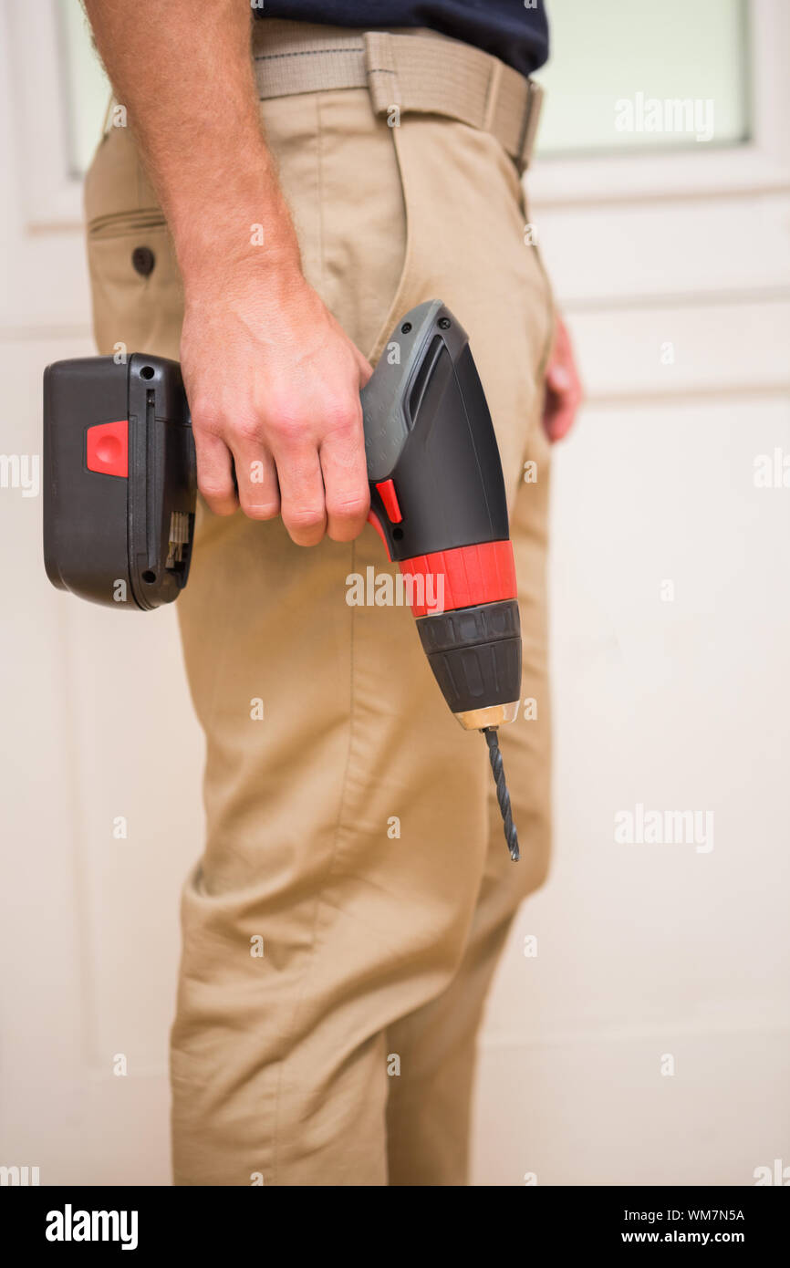 Construction worker holding power tool in a new house Stock Photo - Alamy