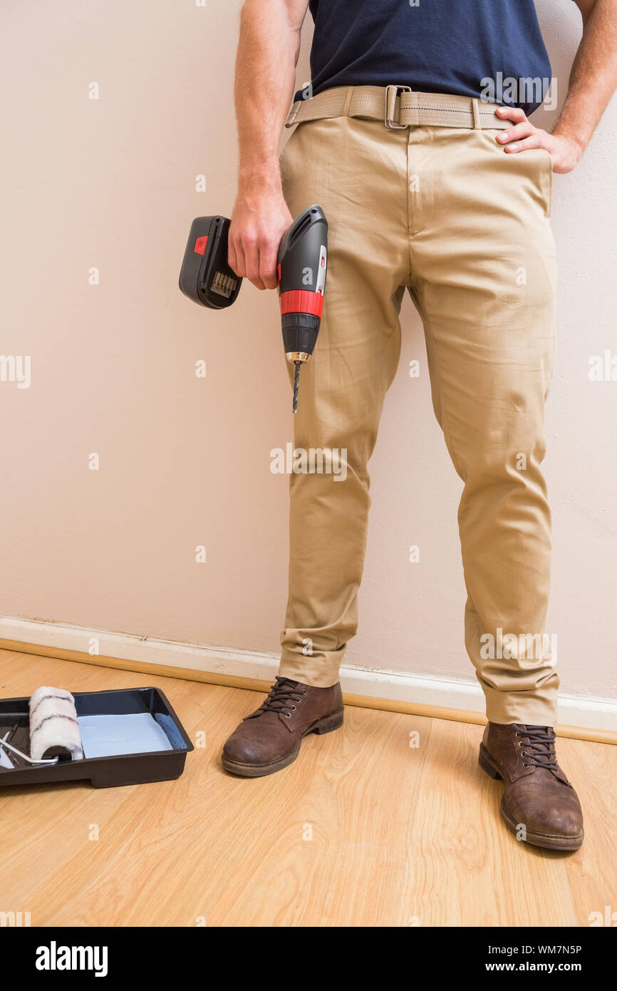 Construction worker holding power tool in a new house Stock Photo - Alamy
