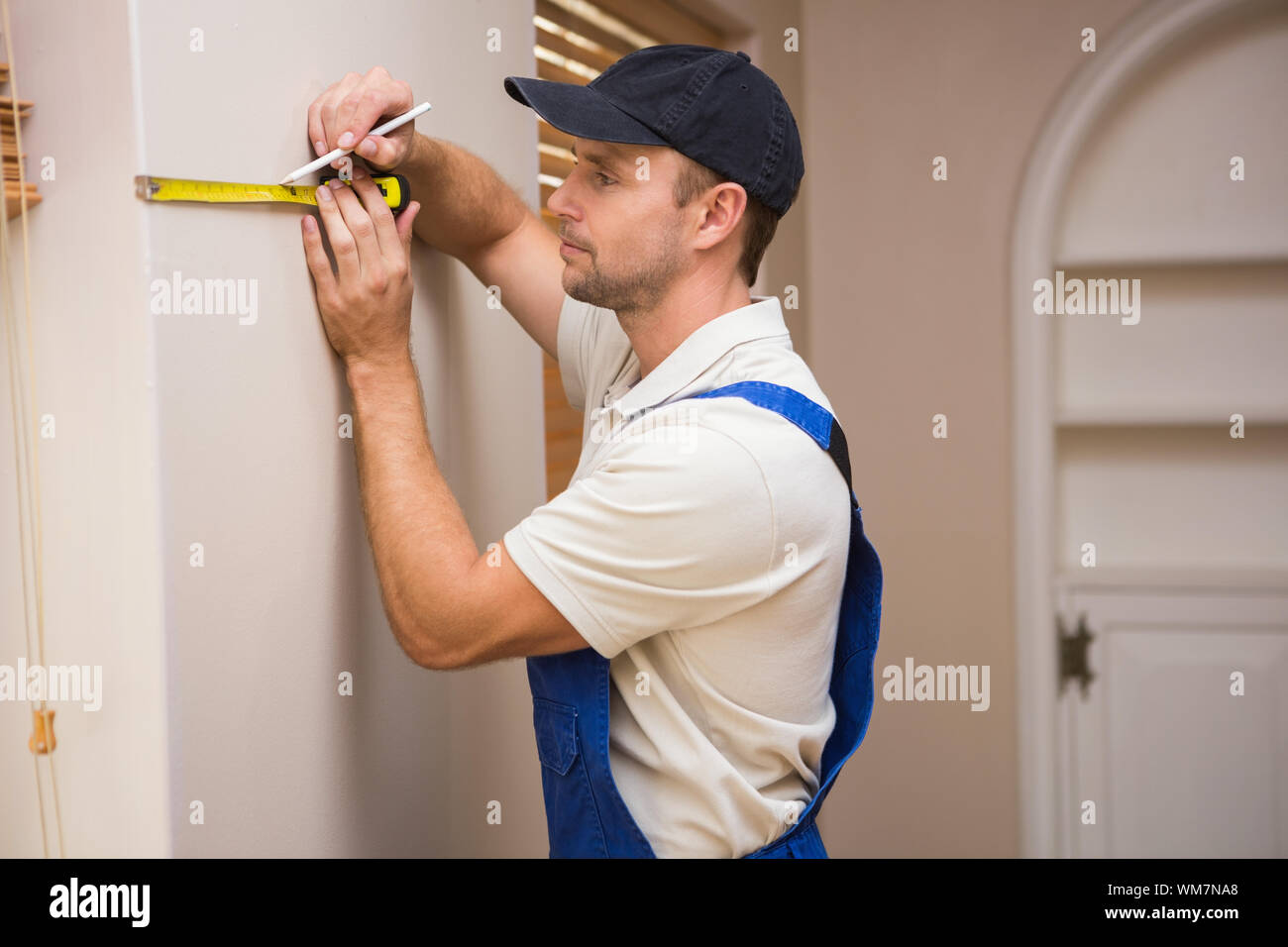 Construction worker using spirit level in a new house Stock Photo - Alamy