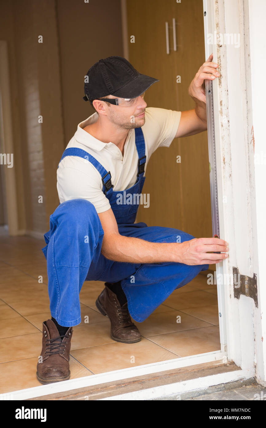 Construction worker using spirit level in a new house Stock Photo - Alamy