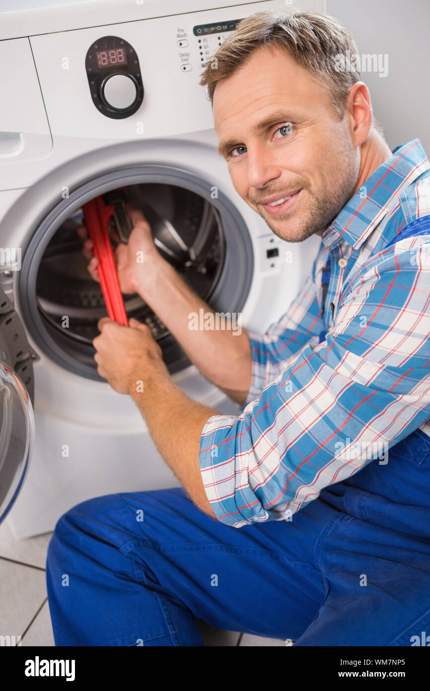 Handyman fixing a washing machine in the kitchen Stock Photo - Alamy