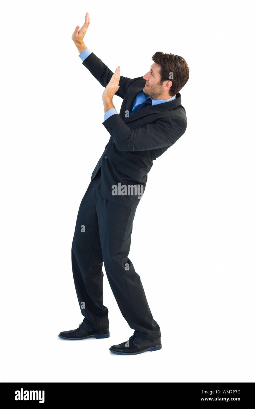 Focused businessman pushing with hands on white background Stock Photo ...