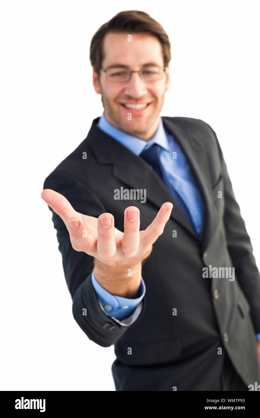 Businessman holding hand out in presentation on white background Stock ...