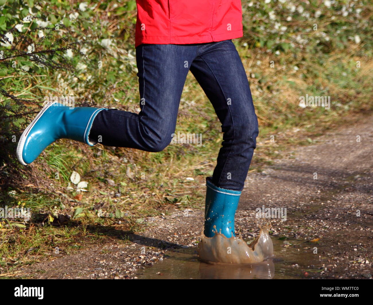 Puddle.Young Woman jumping happy in a puddle during autumn rain Stock ...