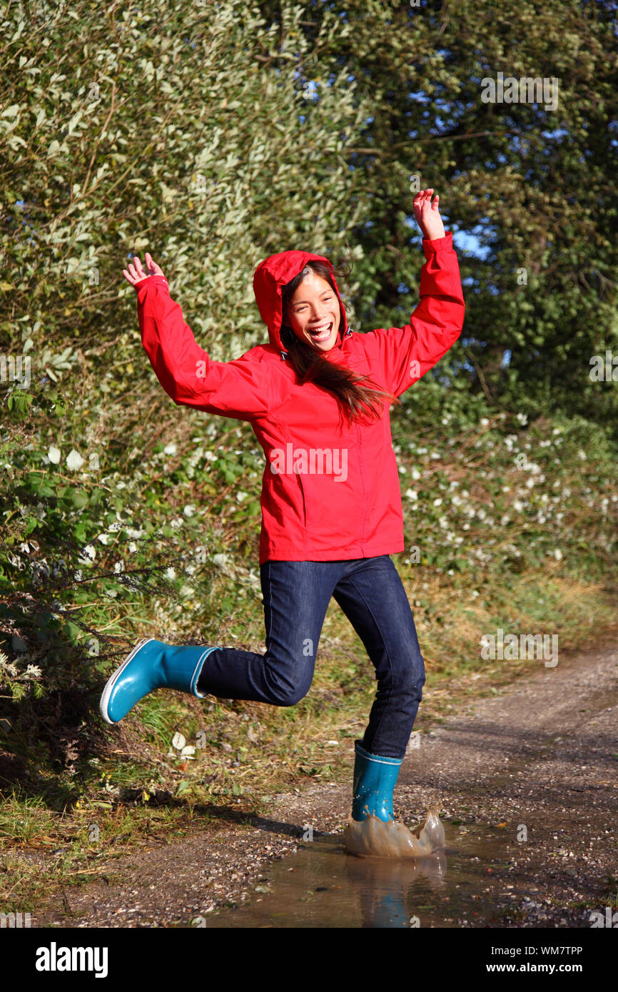 Puddle.Young Woman jumping happy in a puddle during autumn rain Stock ...