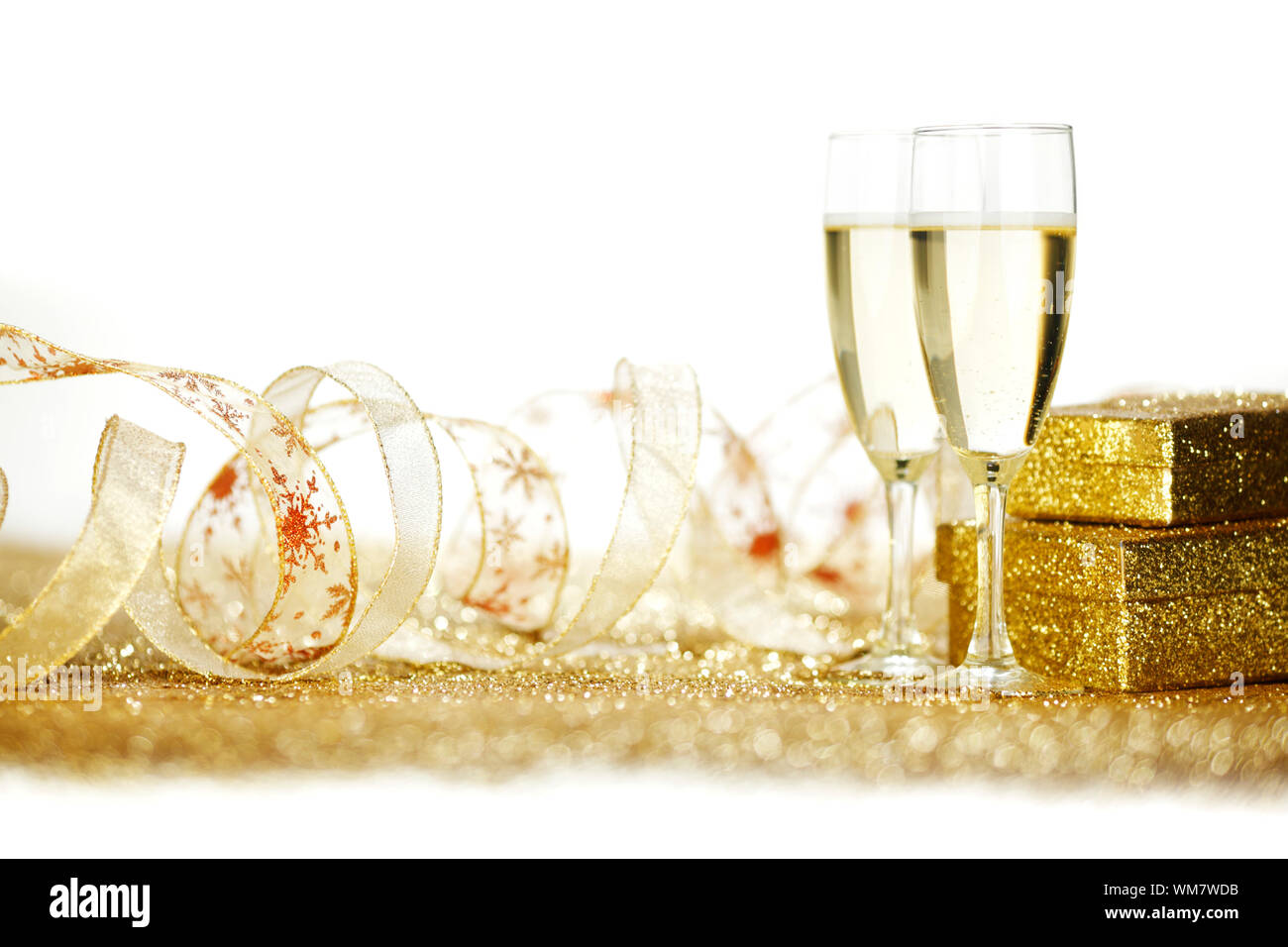 Two elegant flutes of sparkling champagne with decorative golden gifts ...
