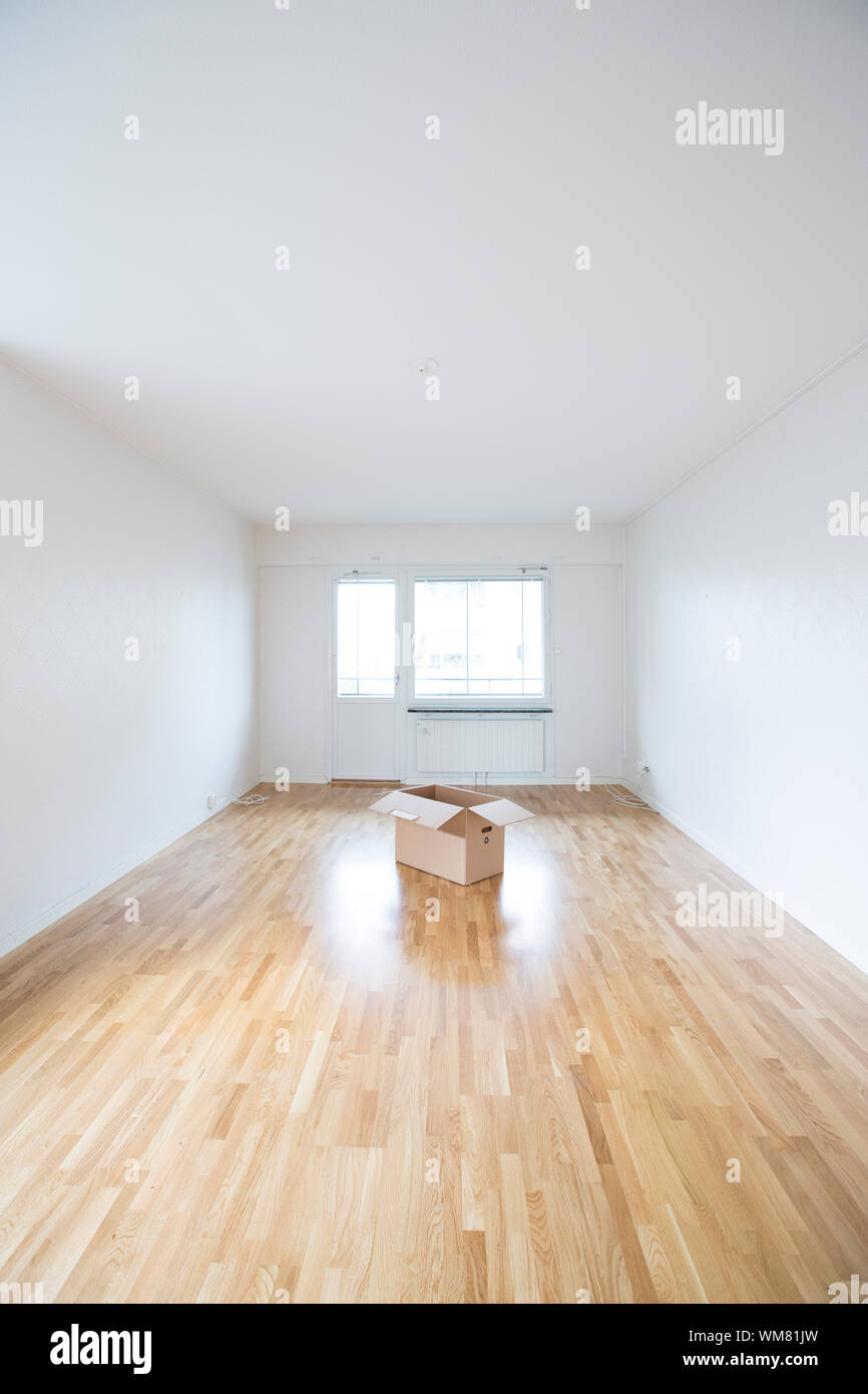 Empty room with a cardboard box in the middle Stock Photo - Alamy