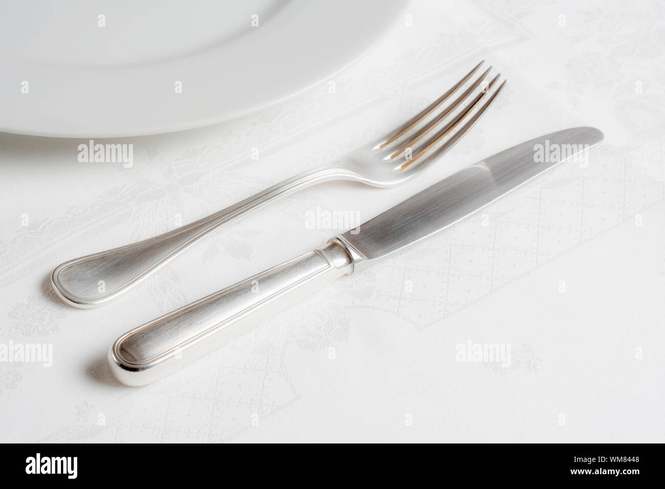 elegant table setting with silverware on white cloth Stock Photo - Alamy