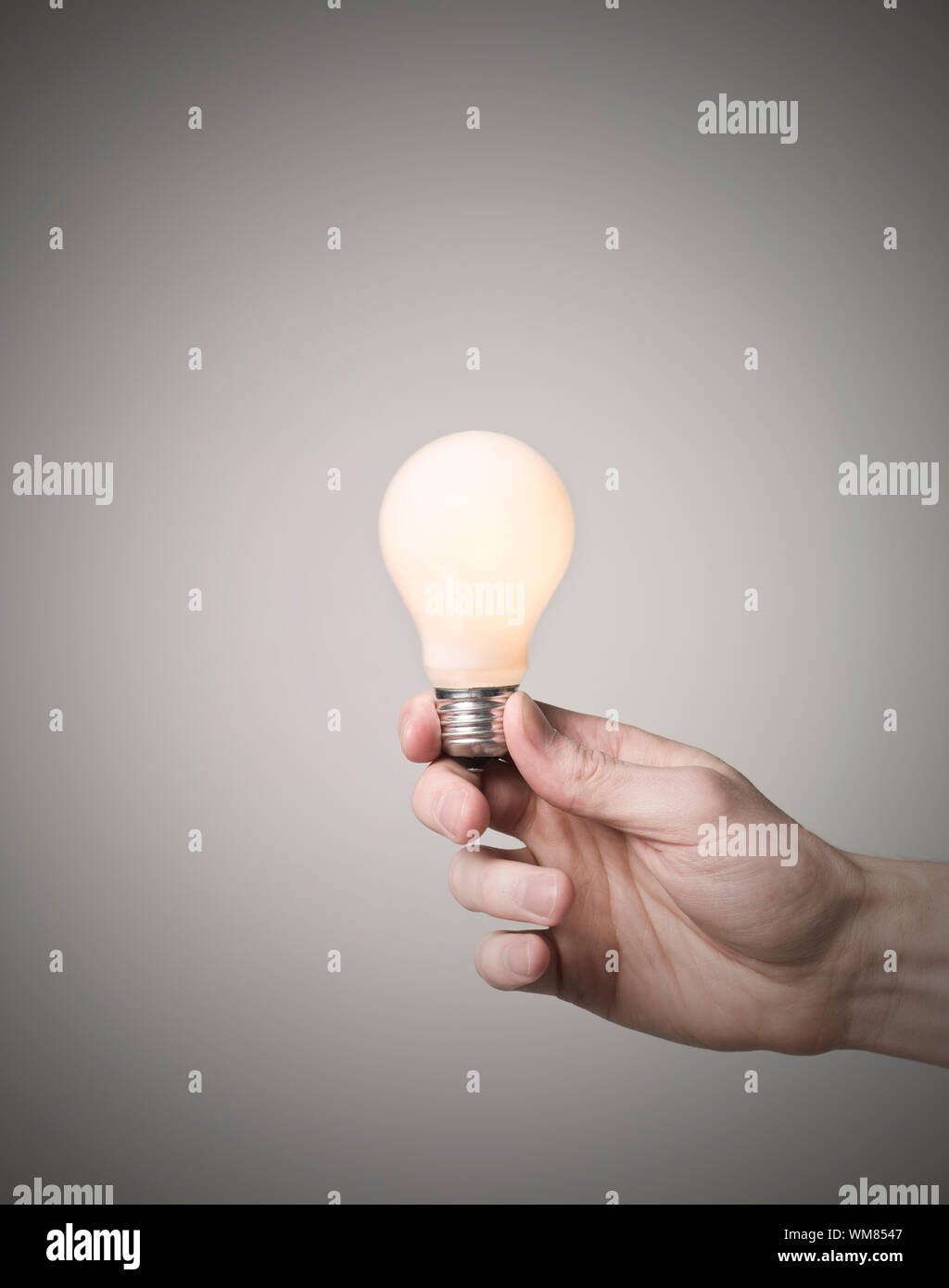 Hand holding shining light bulb Stock Photo - Alamy