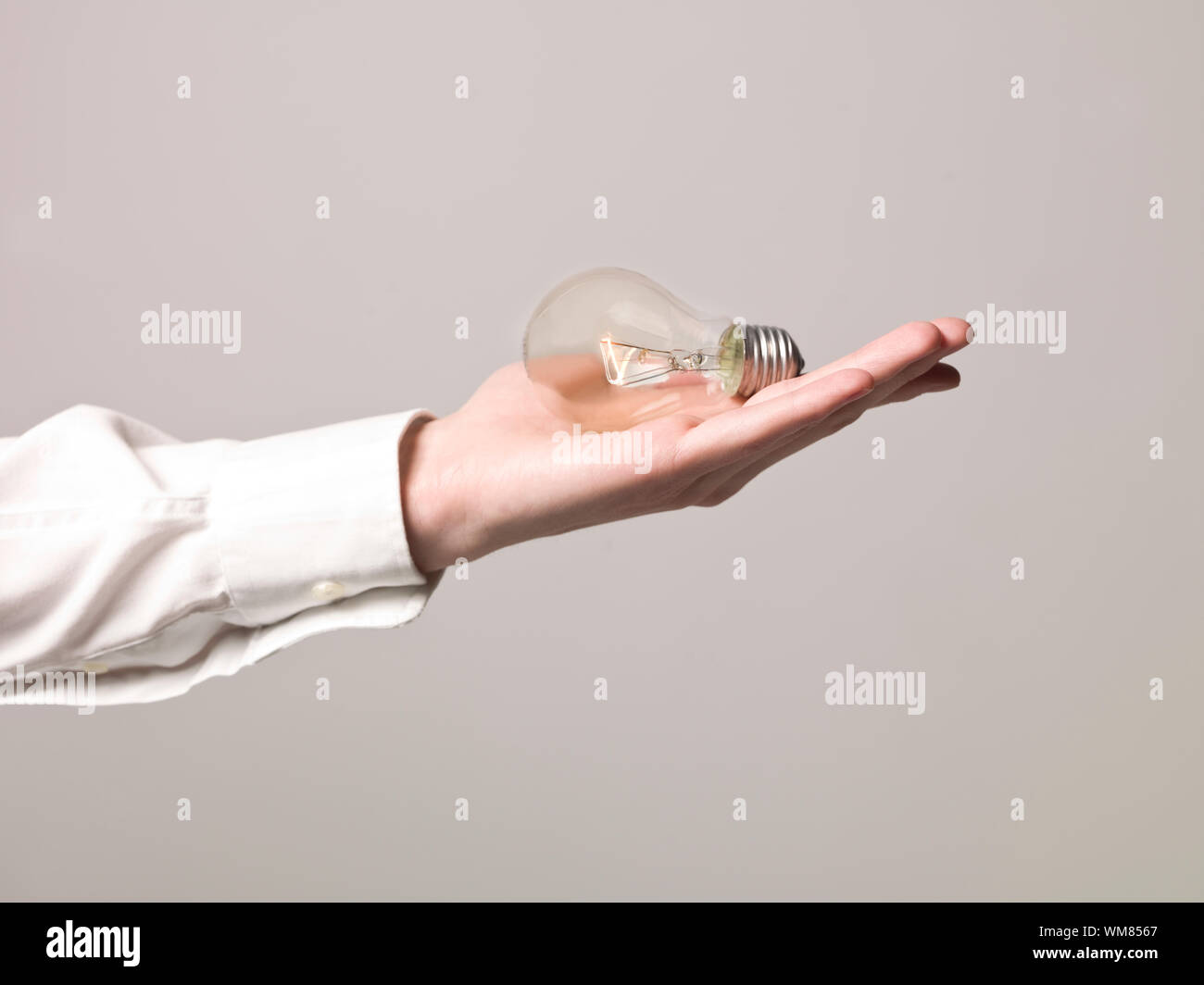 Hand holding shining light-bulb Stock Photo - Alamy