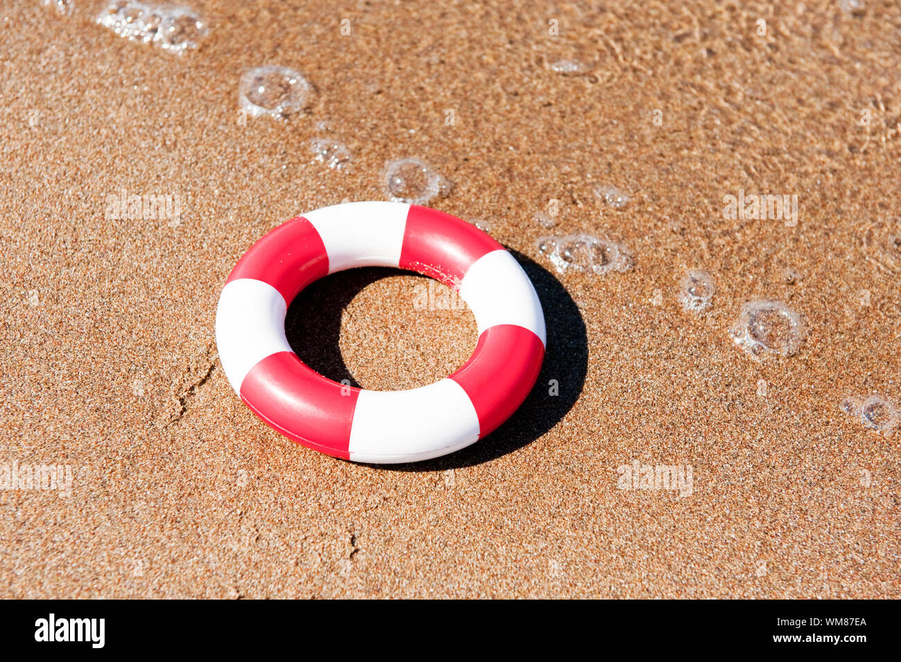 Life buoy in the waterline at the beach Stock Photo - Alamy