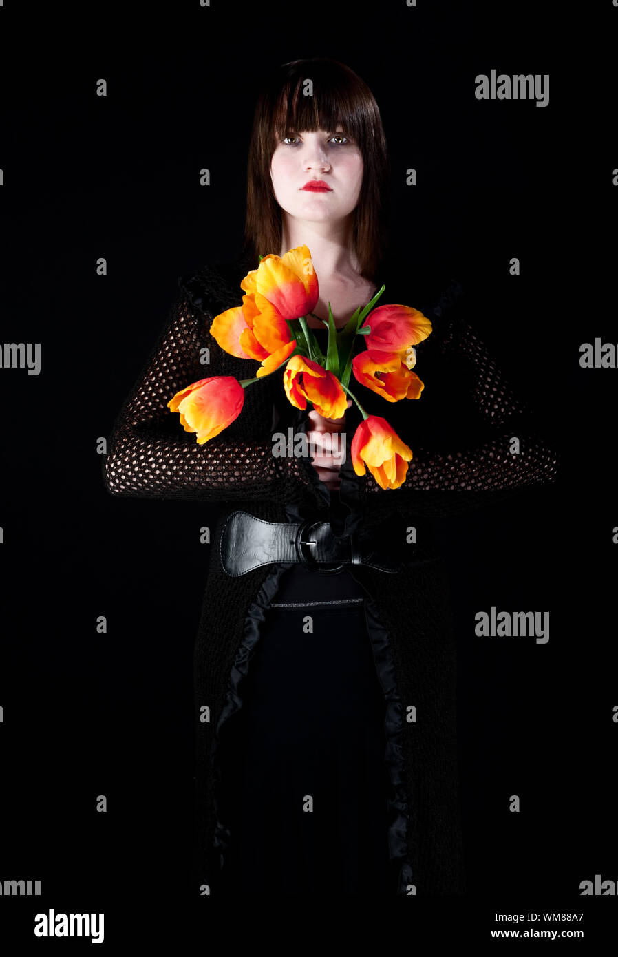 Pretty goth girl in black dress with plastic tulips Stock Photo - Alamy