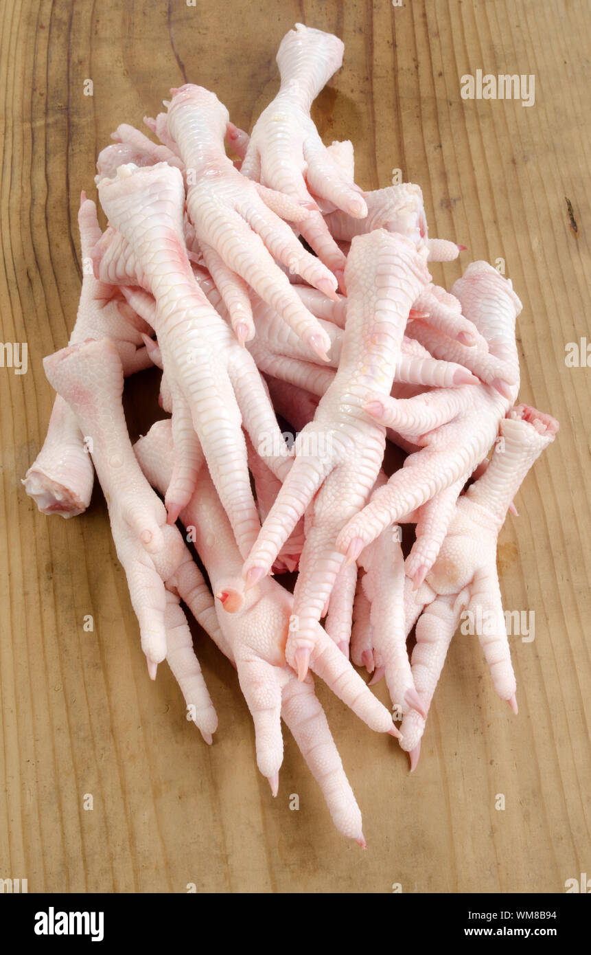 cold chicken feet on a wooden table Stock Photo - Alamy