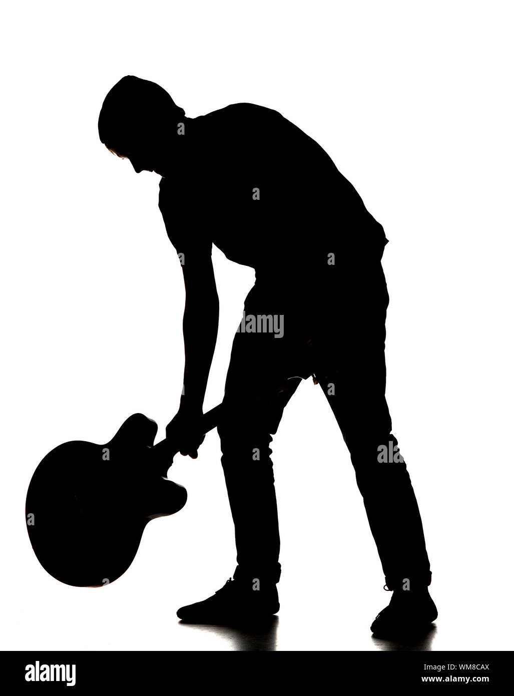 silhouette of a man smashing his guitar Stock Photo - Alamy