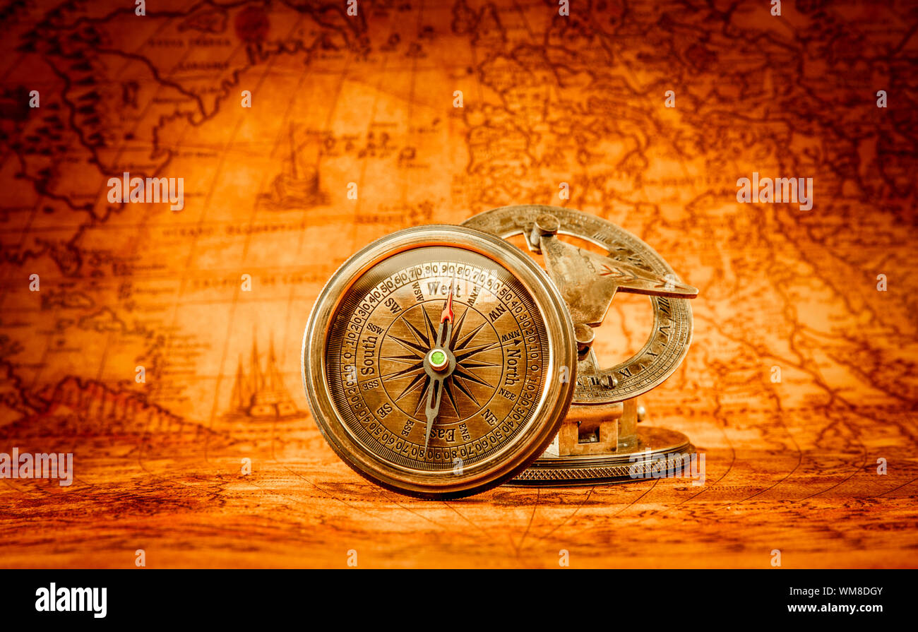 Vintage still life. Vintage compass lies on an ancient world map in ...