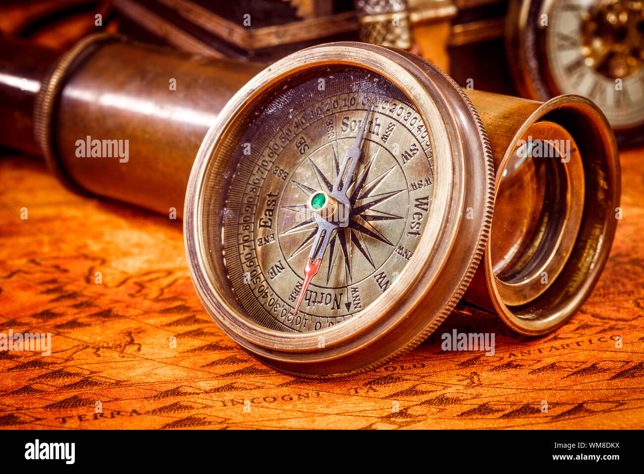 Vintage still life. Vintage compass lies on an ancient world map in ...