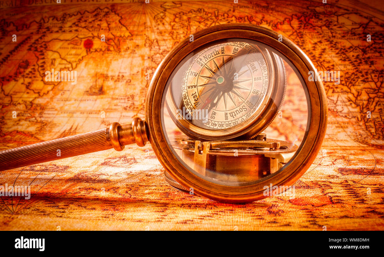 Vintage still life. Vintage magnifying glass lies on an ancient world ...