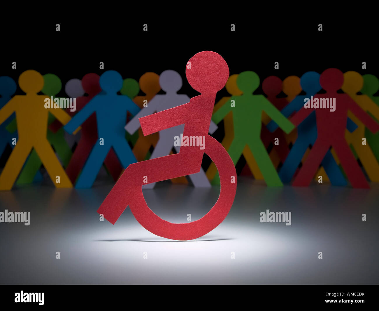 A disable paper figure stands under the spotlight on his wheelchair ...