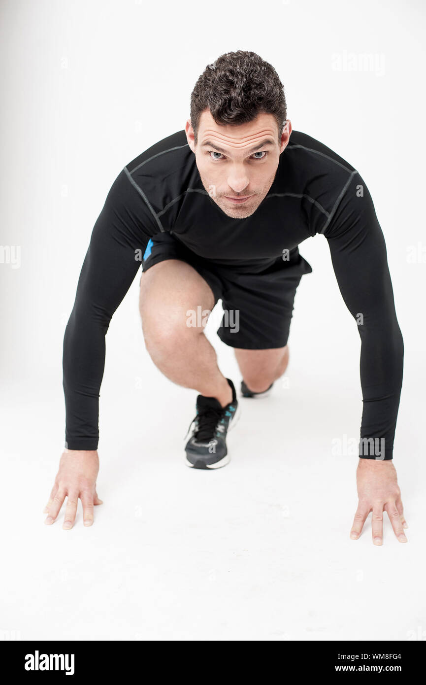 Competitive male athlete getting ready to run Stock Photo - Alamy