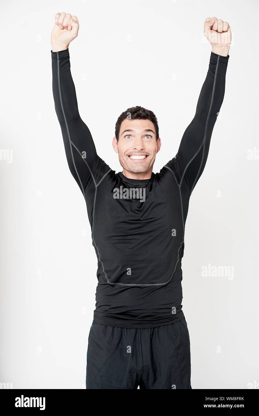 Athletic man with arms raised, winning gesture Stock Photo - Alamy